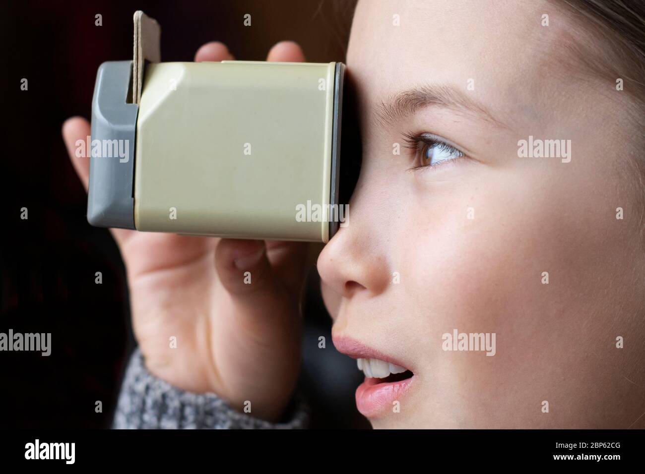 Child girl looks at old photos through a diascope Stock Photo - Alamy