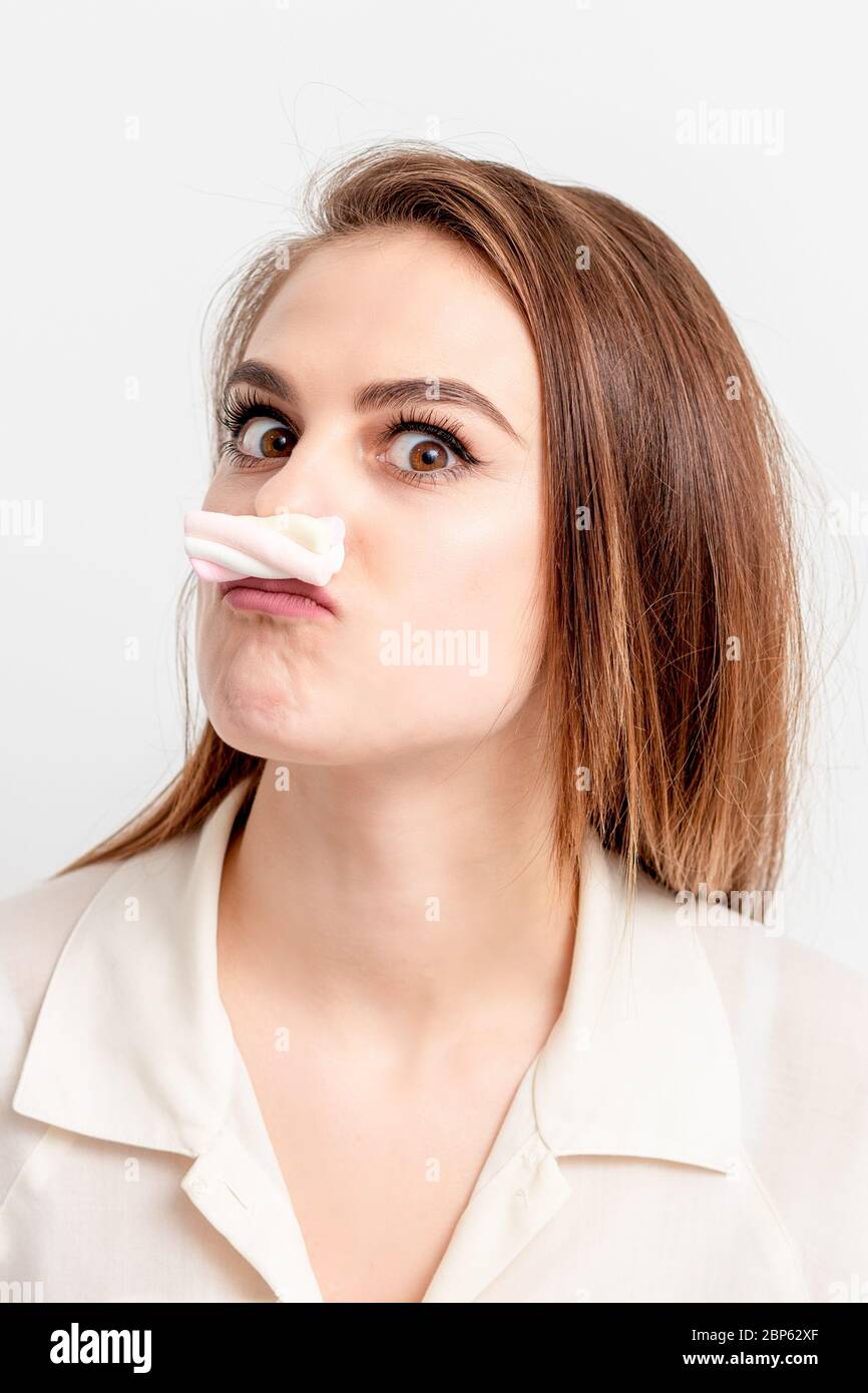 Sweet candy marshmallow like mustache over lips of young woman on white ...
