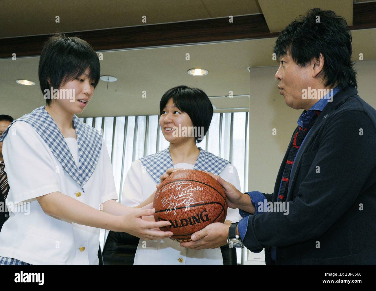 Japanese pop singer Nobuteru Maeda (R) hands a Michael Jordan ...