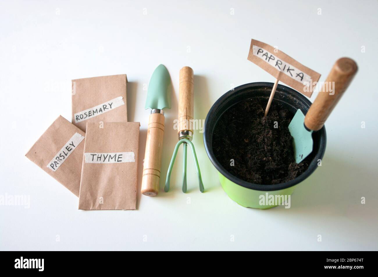 Gardening time, paper bags with seeds and tools for planting. Pot with ...
