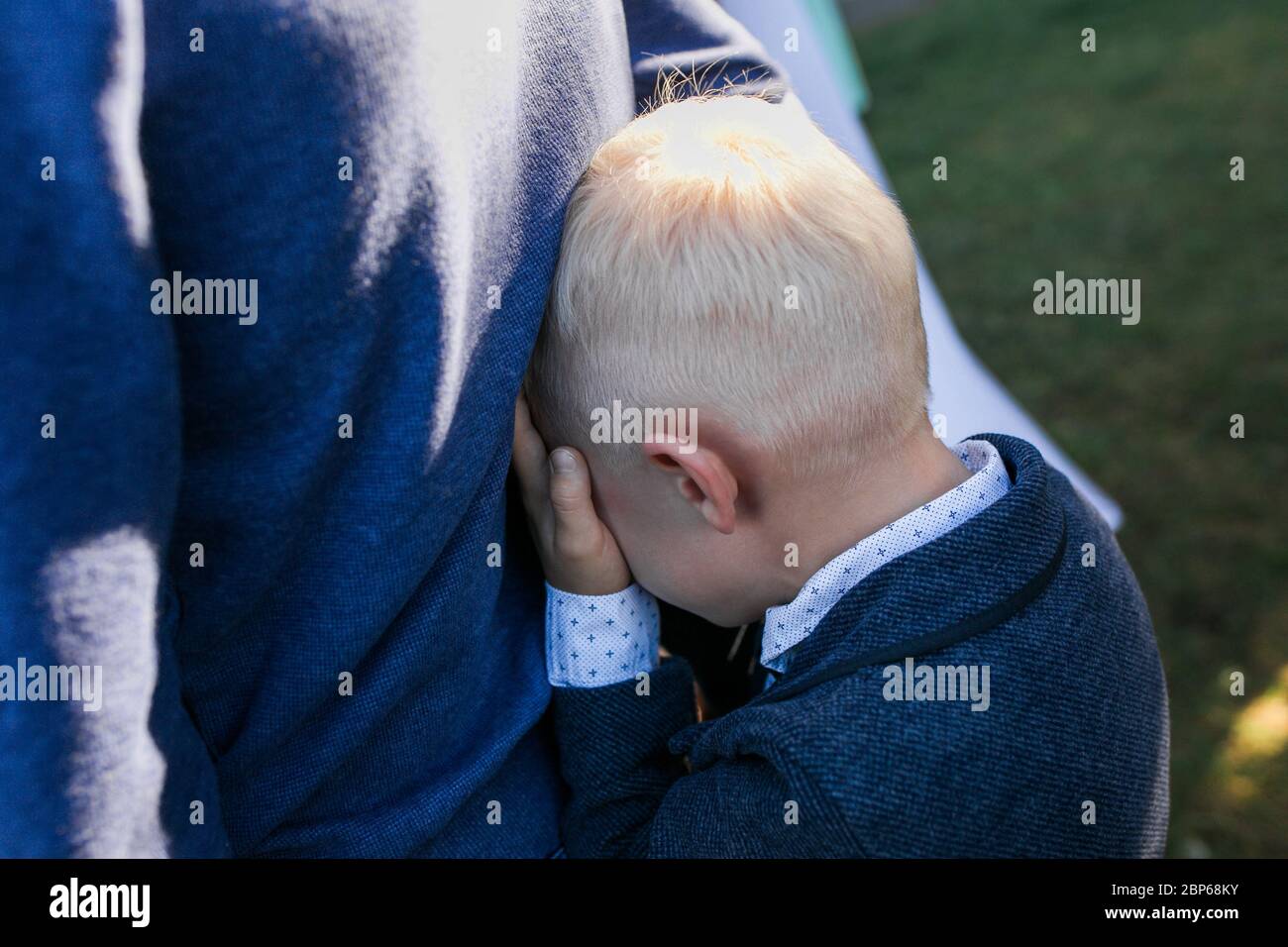 little boy hiding behind his father Stock Photo - Alamy