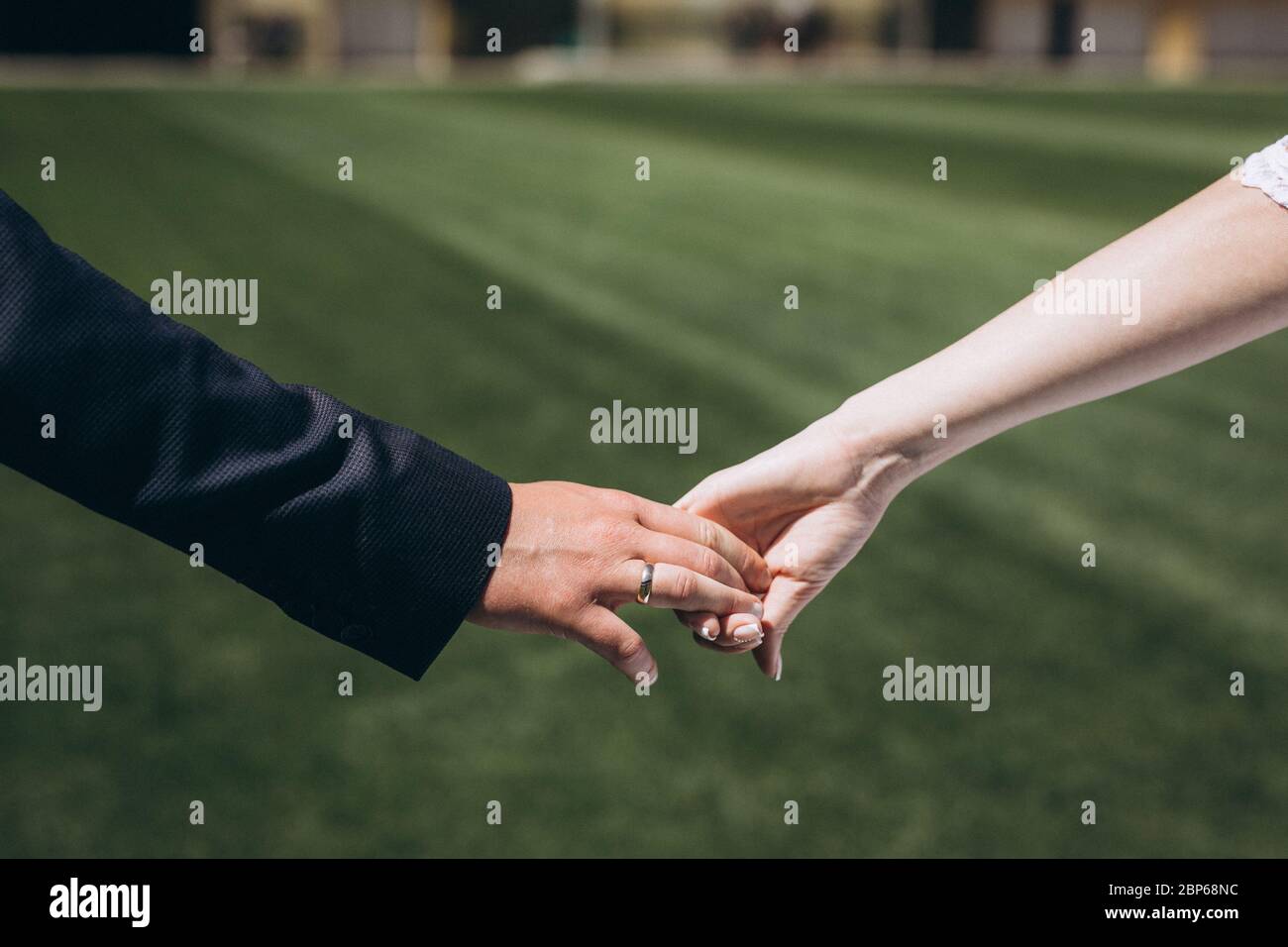 young white man gently touches the hand of his bride Stock Photo - Alamy
