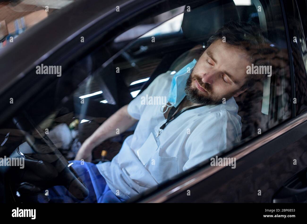 Tired and exhausted doctor sitting in car after long and difficult ...