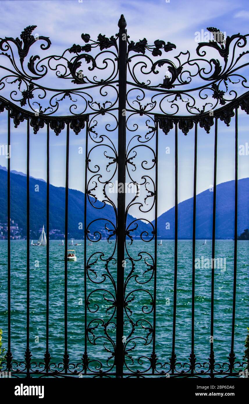 spectacular view of lake Lugano over a luxurious wrought iron gate ...