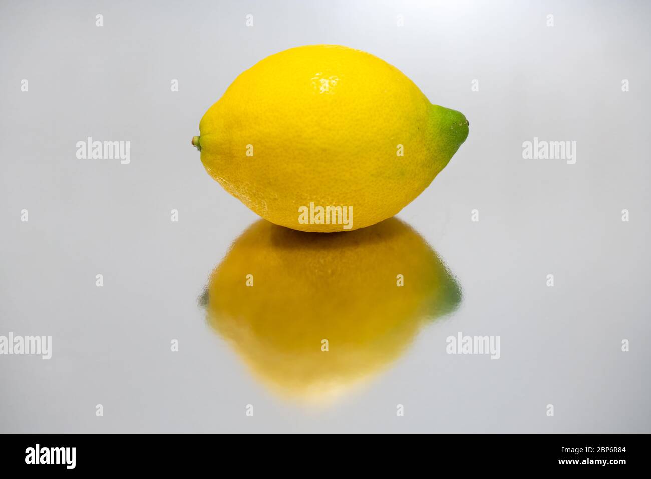 Whole bright yellow lemon isolated and reflected Stock Photo - Alamy