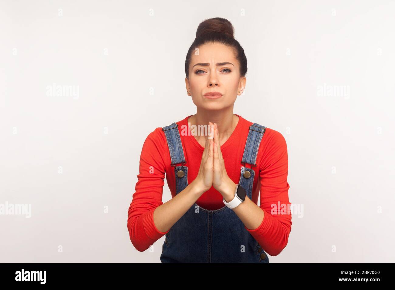 Please, I need! Portrait of imploring worried girl with hair bun in ...