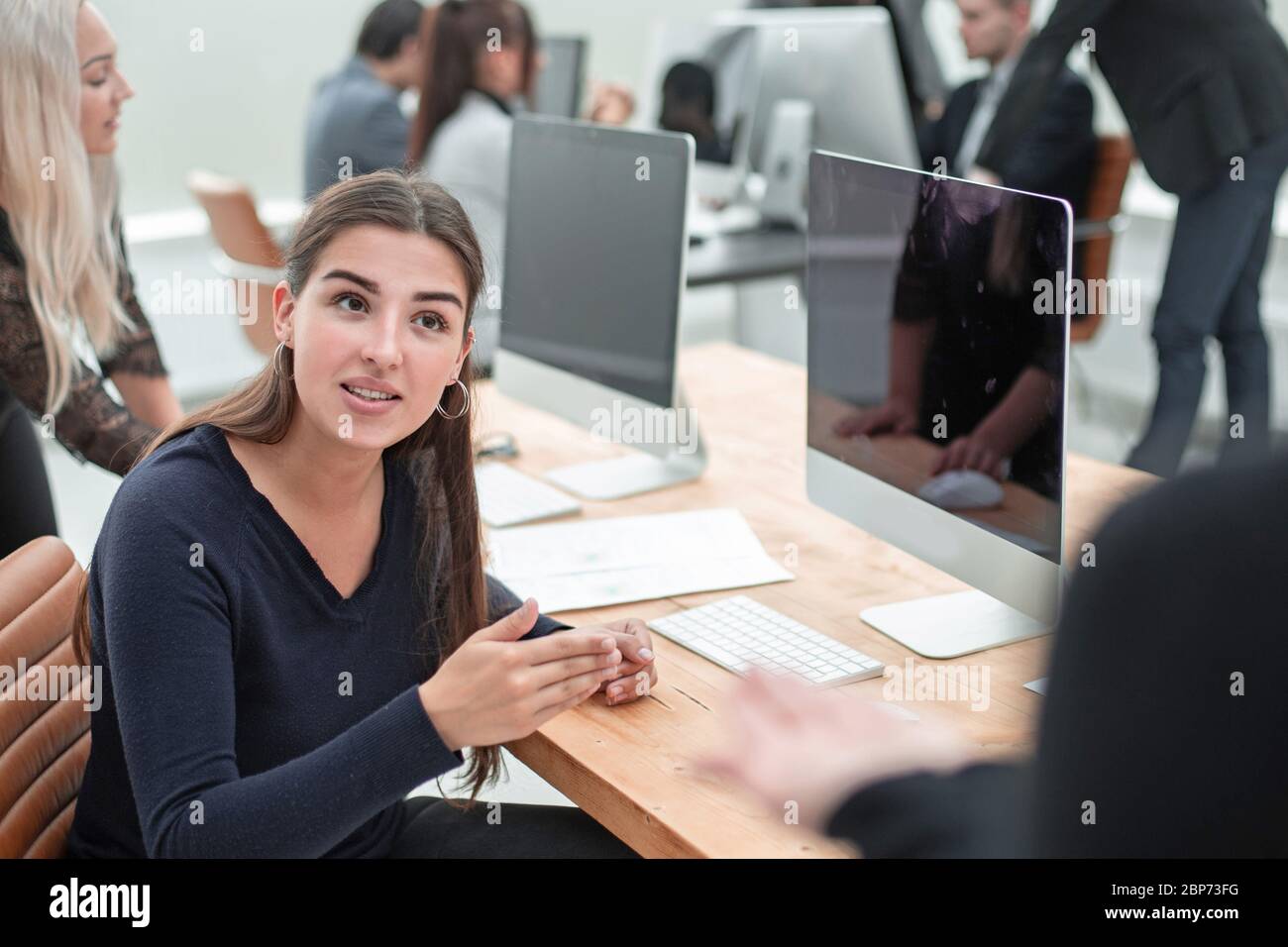 serious young woman asking a question to her colleague Stock Photo - Alamy