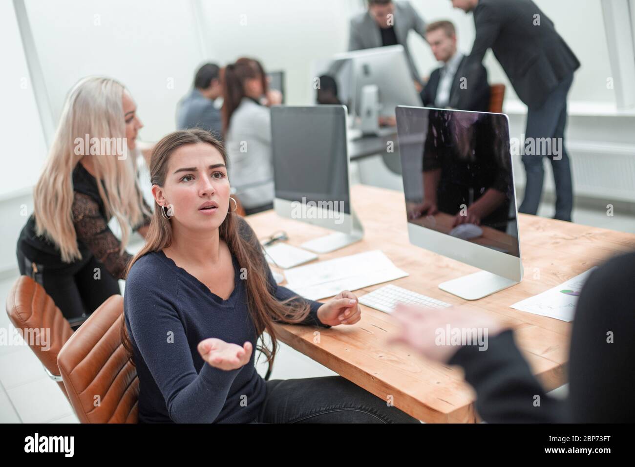 serious young woman asking a question to her colleague Stock Photo - Alamy