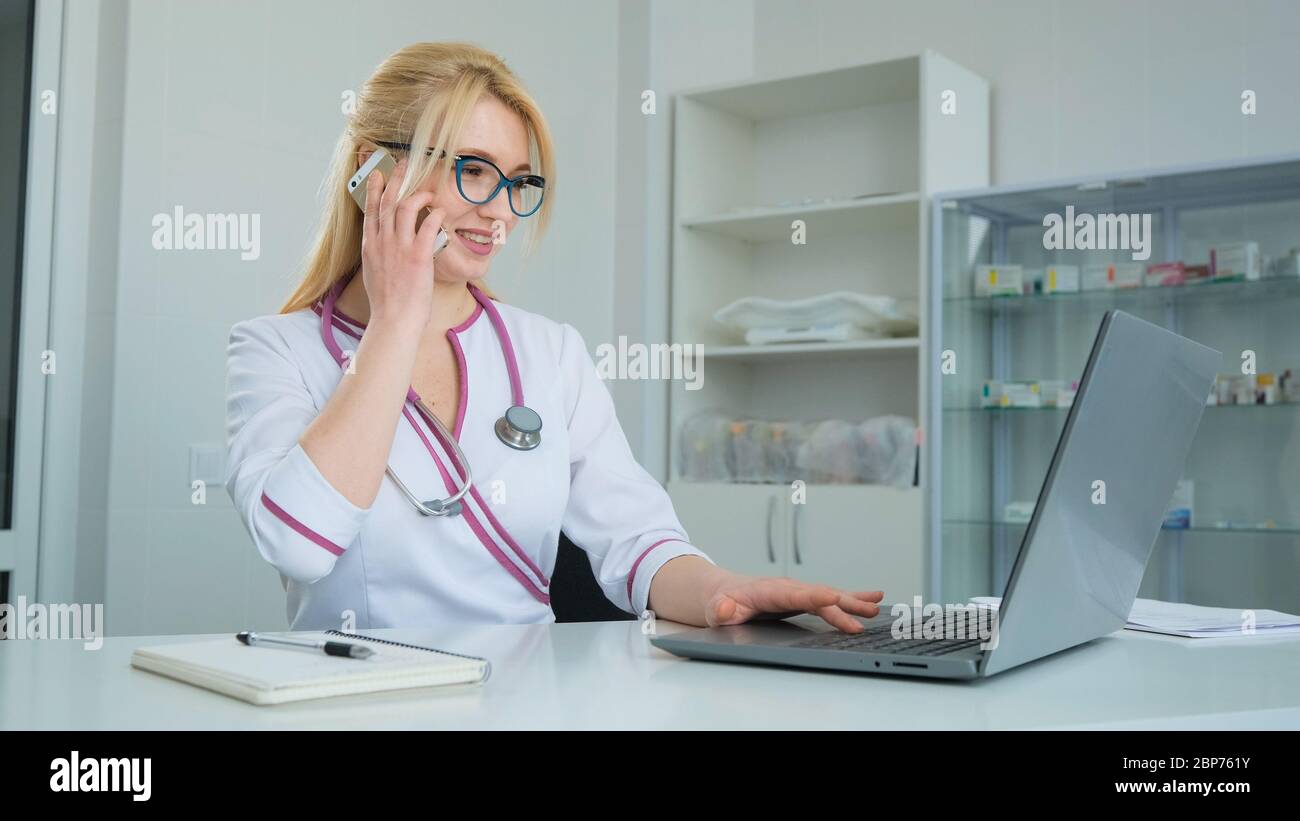 Smiling doctor using laptop 4k hi-res stock photography and images - Alamy