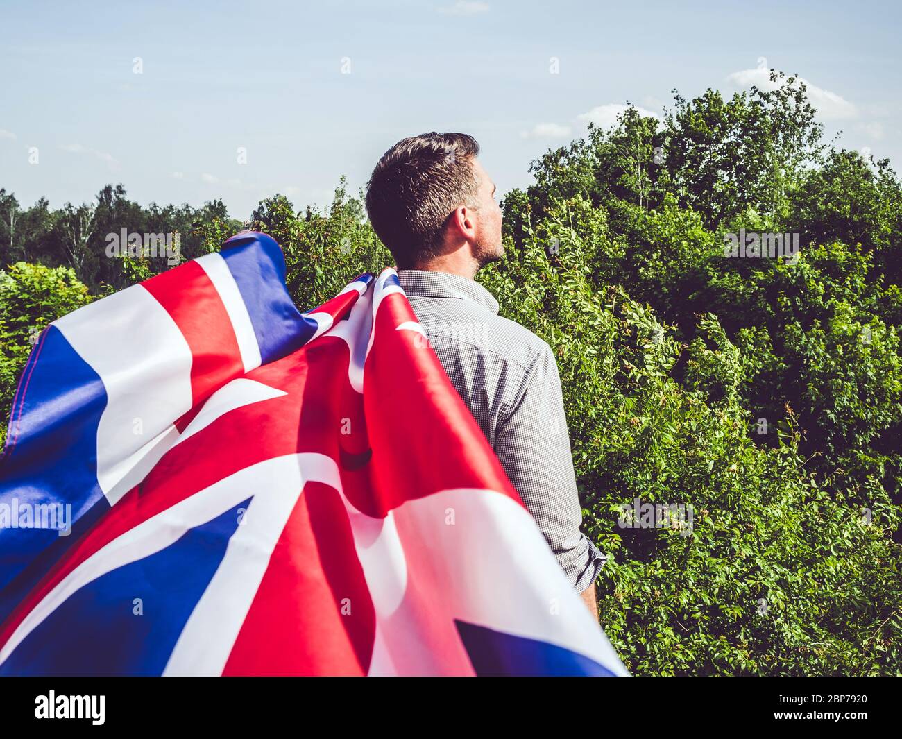 Uk flag waving blue sky hands hi-res stock photography and images - Alamy