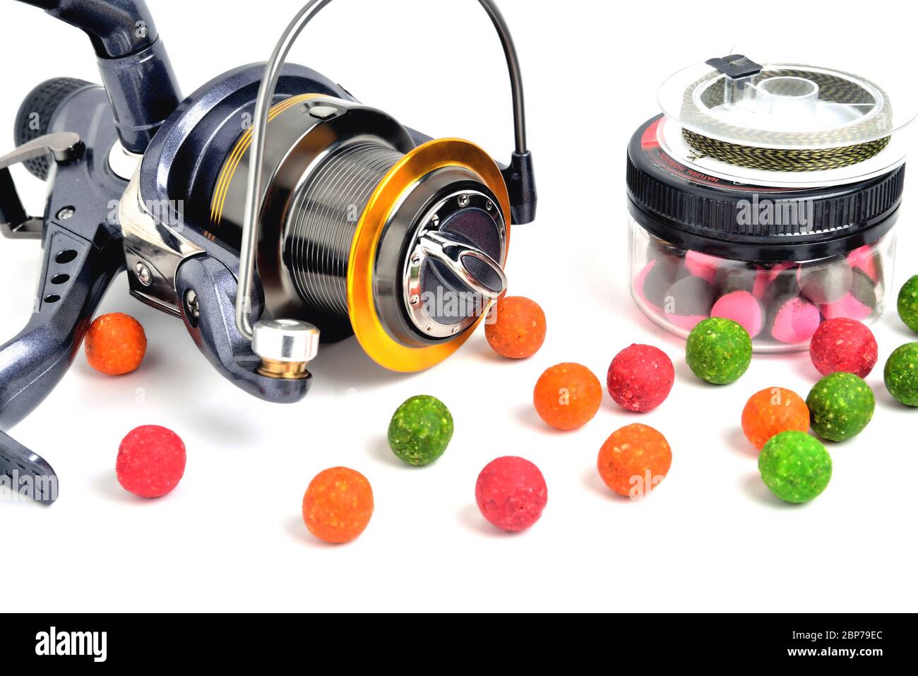 Fishing coil, colored boilies, braided cord, on white background, close ...