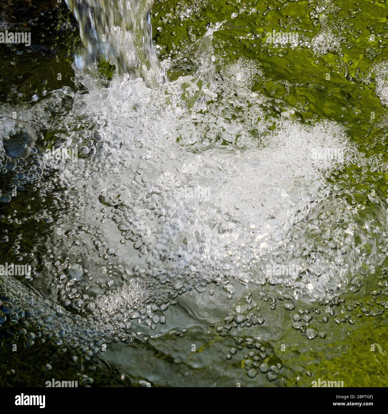 Water jet splashing in a public fountain, Cerin, Bugey Massif, Ain ...