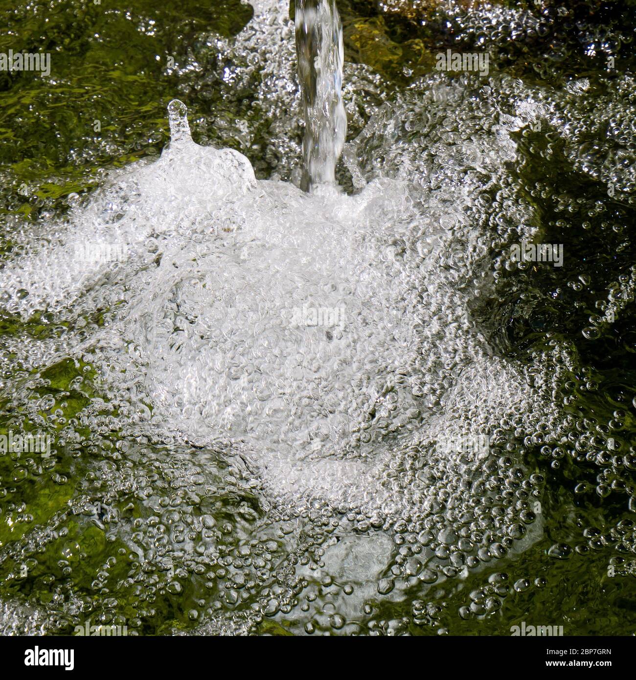 Water jet splashing in a public fountain, Cerin, Bugey Massif, Ain ...