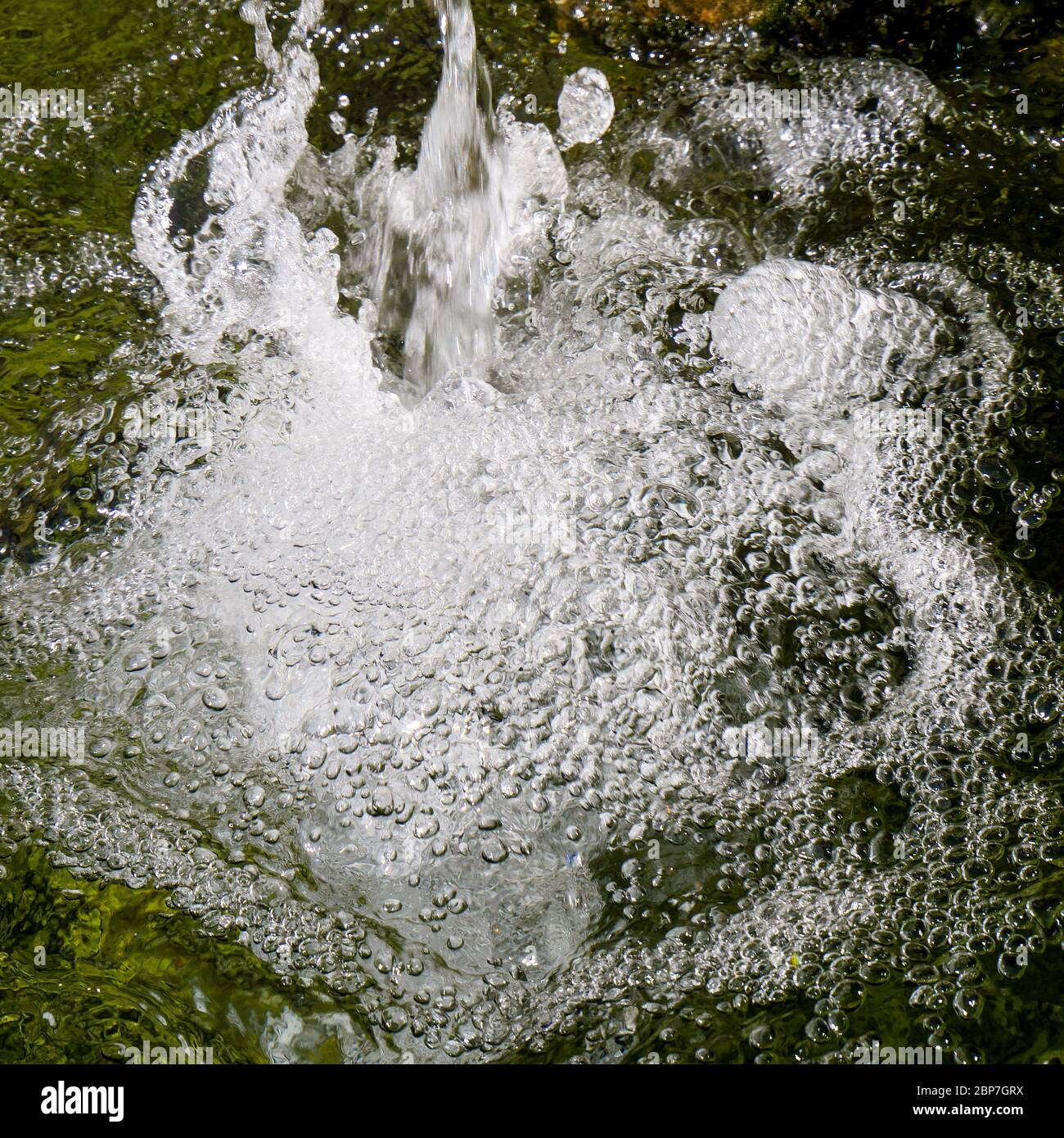 Water jet splashing in a public fountain, Cerin, Bugey Massif, Ain ...
