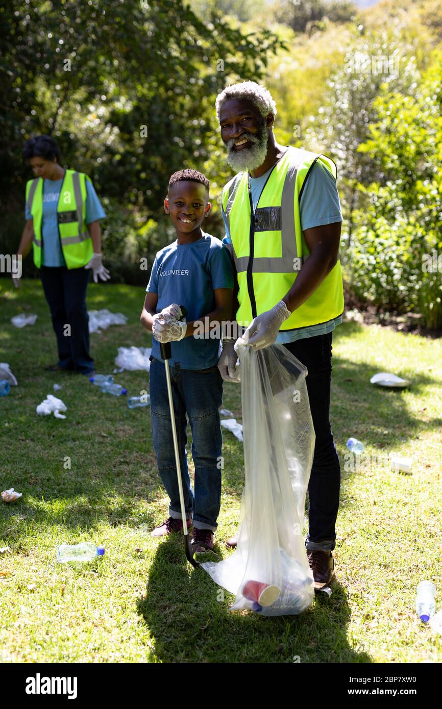 Senior African American man and boy collecting garbage Stock Photo - Alamy