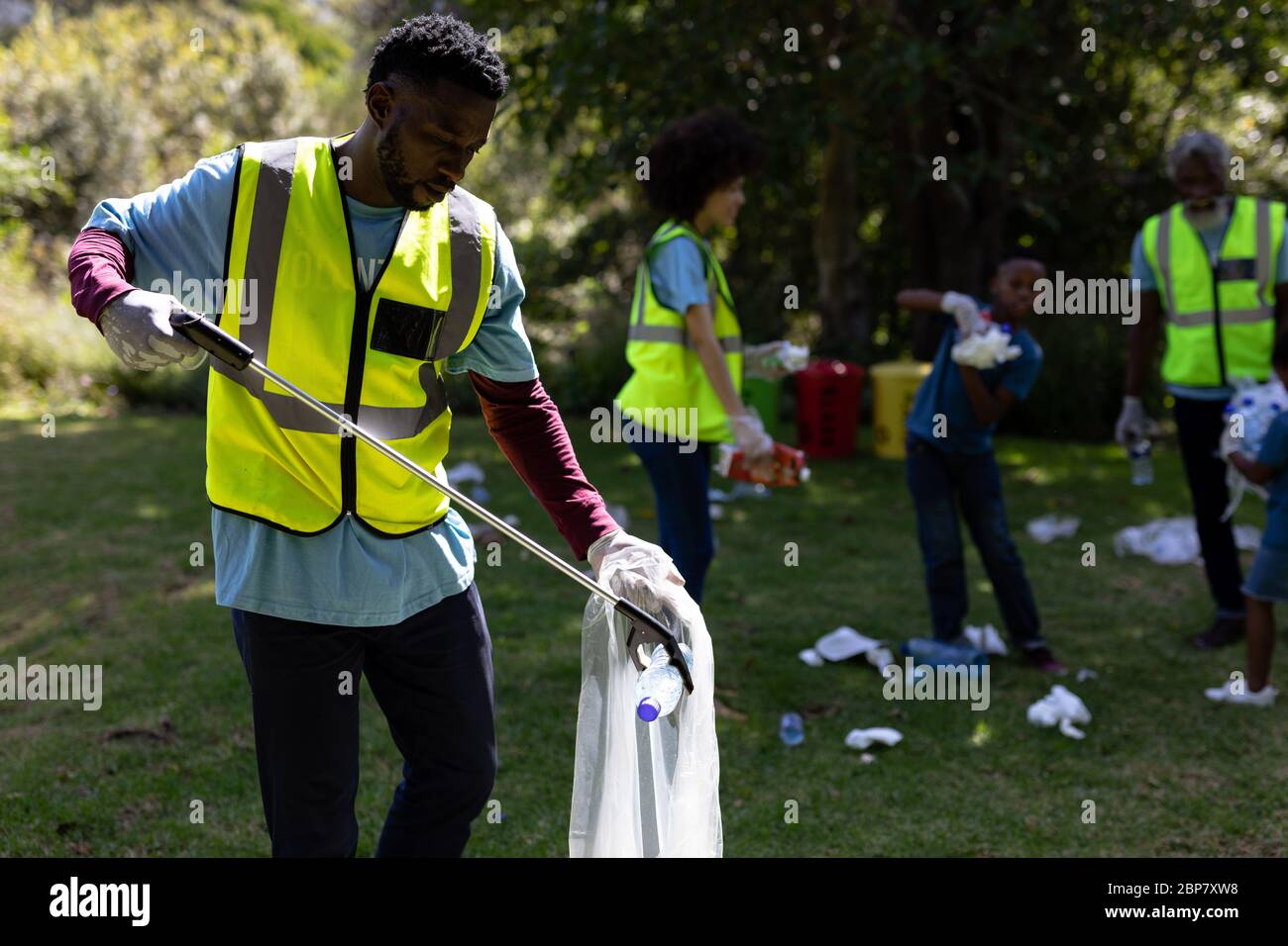 Multi-generation mixed race family collecting garbage Stock Photo - Alamy