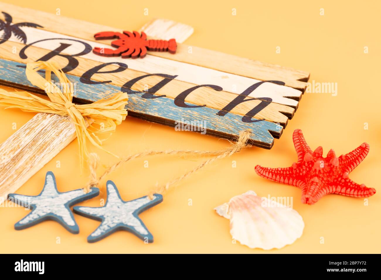 Wooden sign beach, starfish and shell on yellow background Stock Photo ...