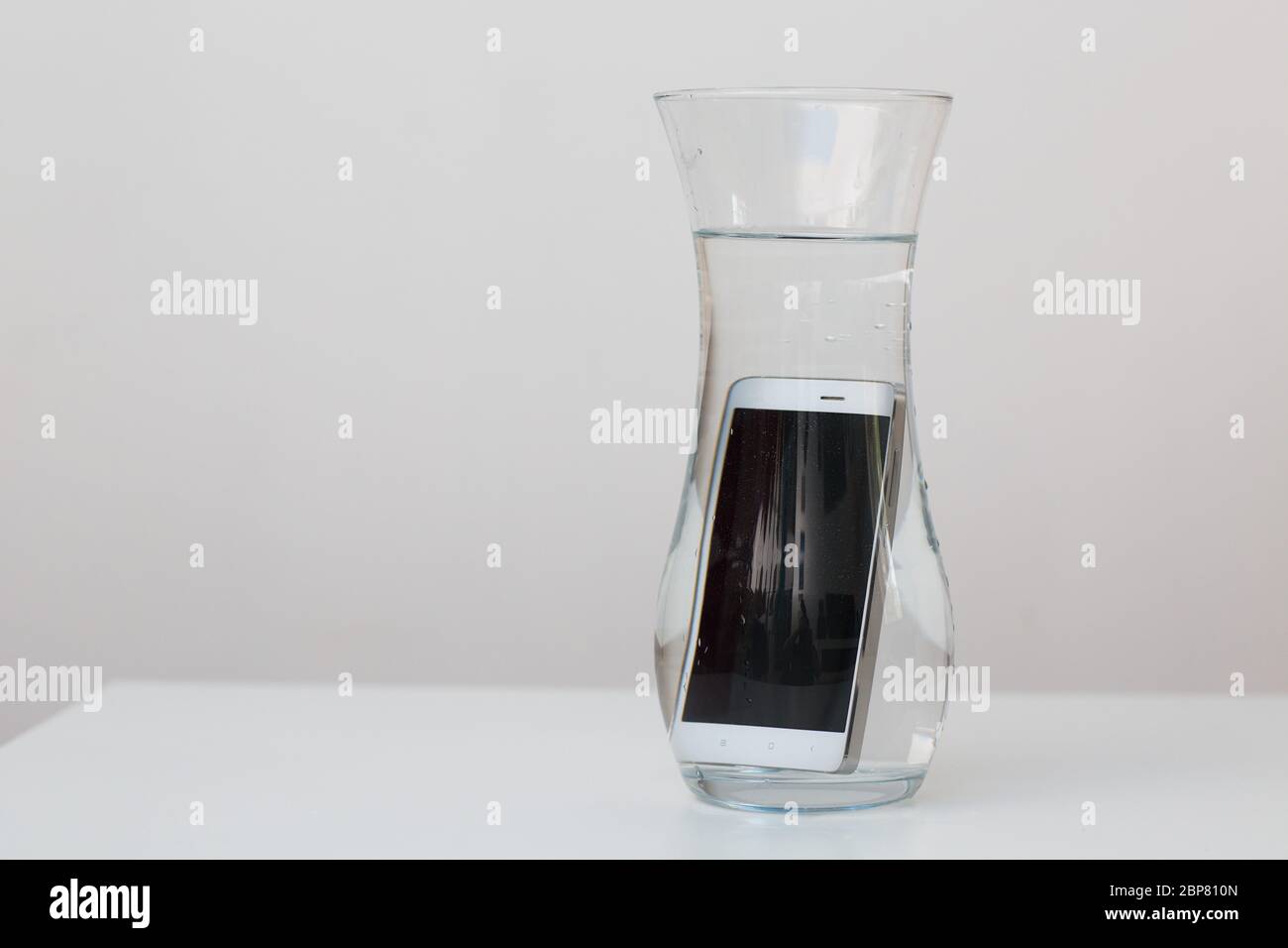 Mobile phone in vessel with water Stock Photo - Alamy