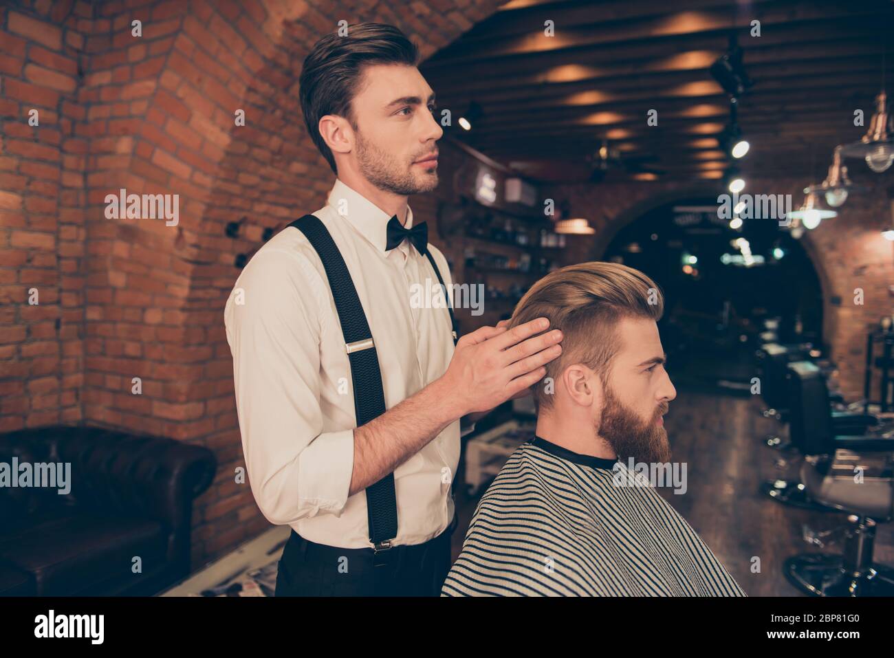 Side view of attractive classy dressed barber shop stylist, which is ...