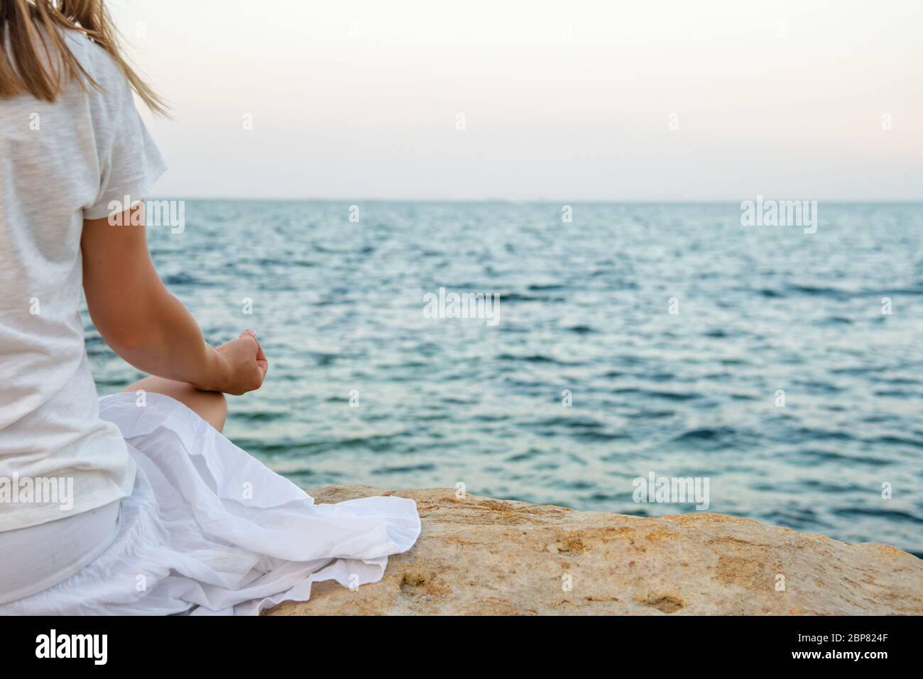 Woman meditating at the sea Stock Photo - Alamy