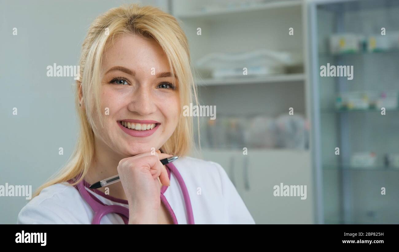 Happy Caucasian woman blonde doctor in white medical coat and ...