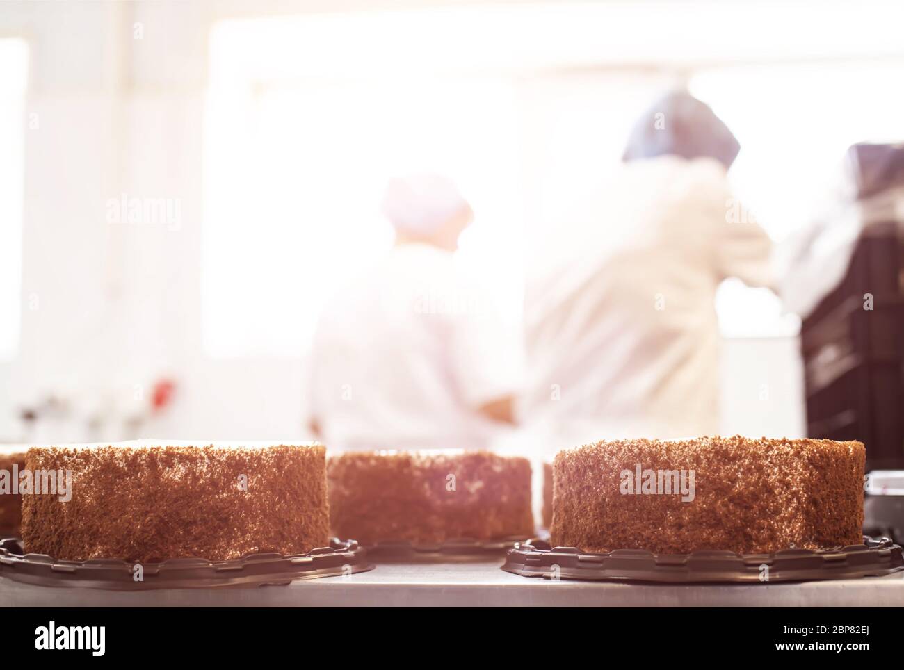 Mass production of cakes and sweets at the confectionery factory. Chefs ...