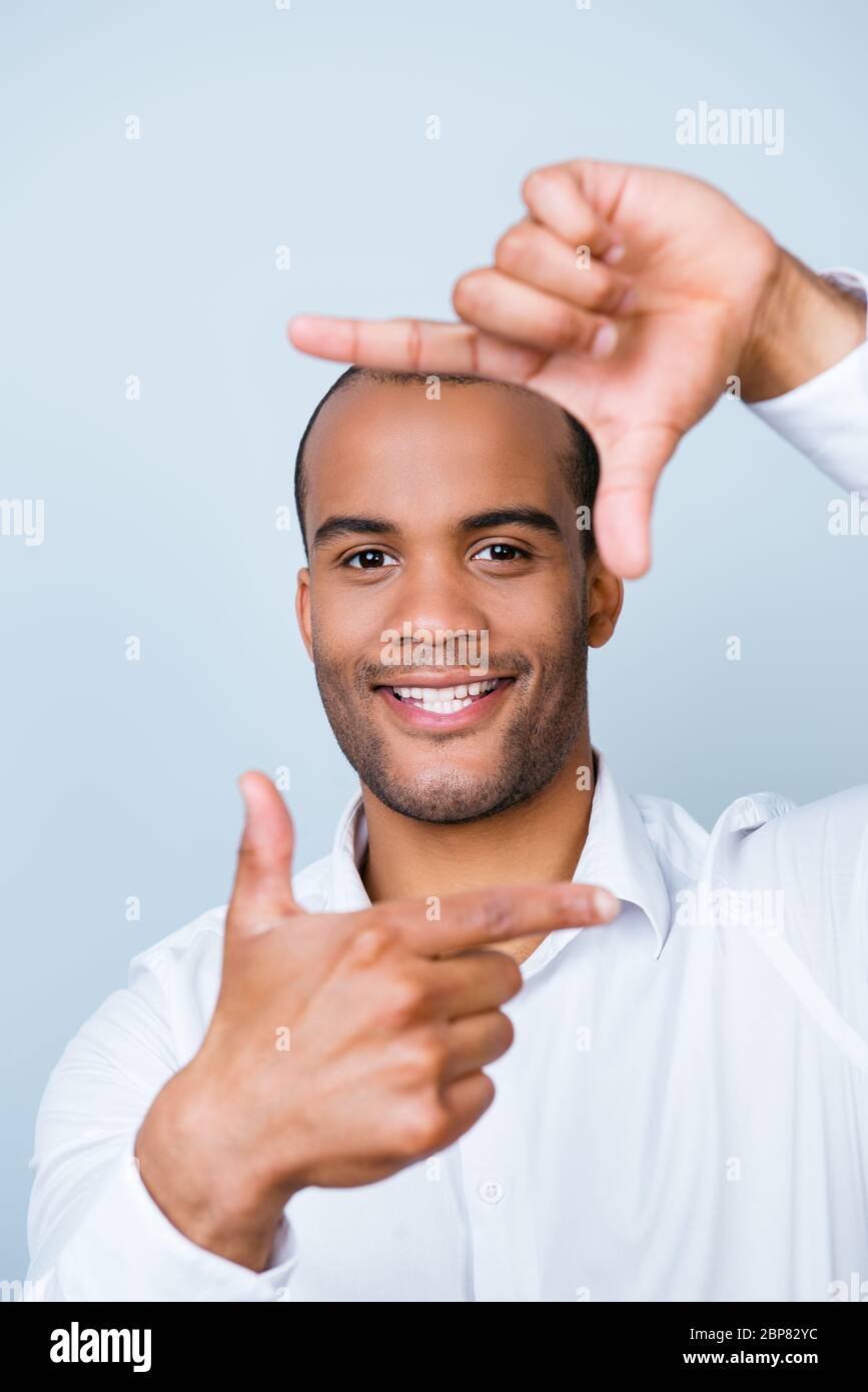 Happy smiling young african guy is making frame with fingers, he has a ...