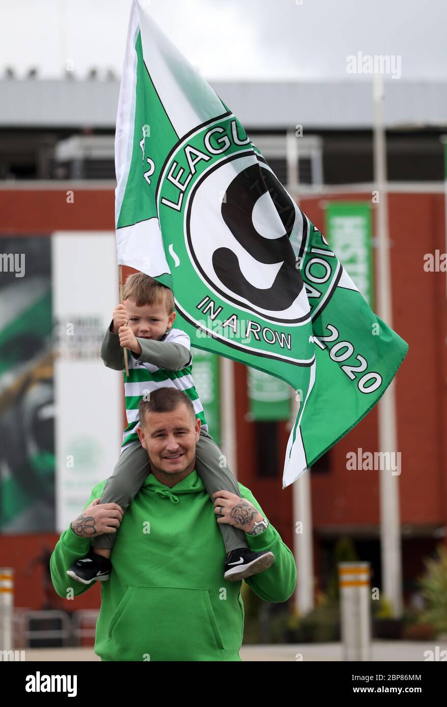 Two Celtic fans hold a League Champions flag outside Celtic Park, home ...