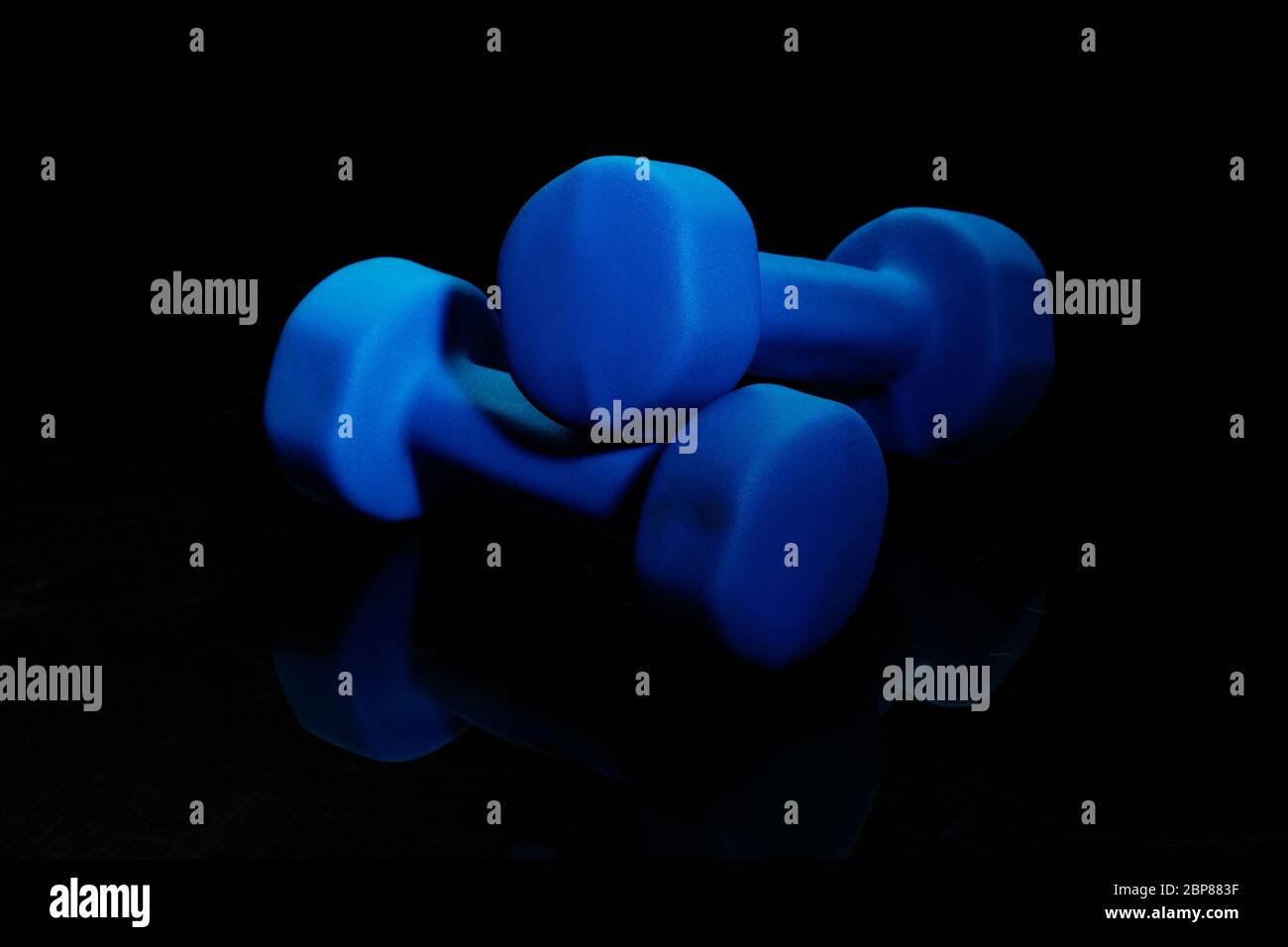 Blue gym weights. Professional sport equipment isolated on black studio ...