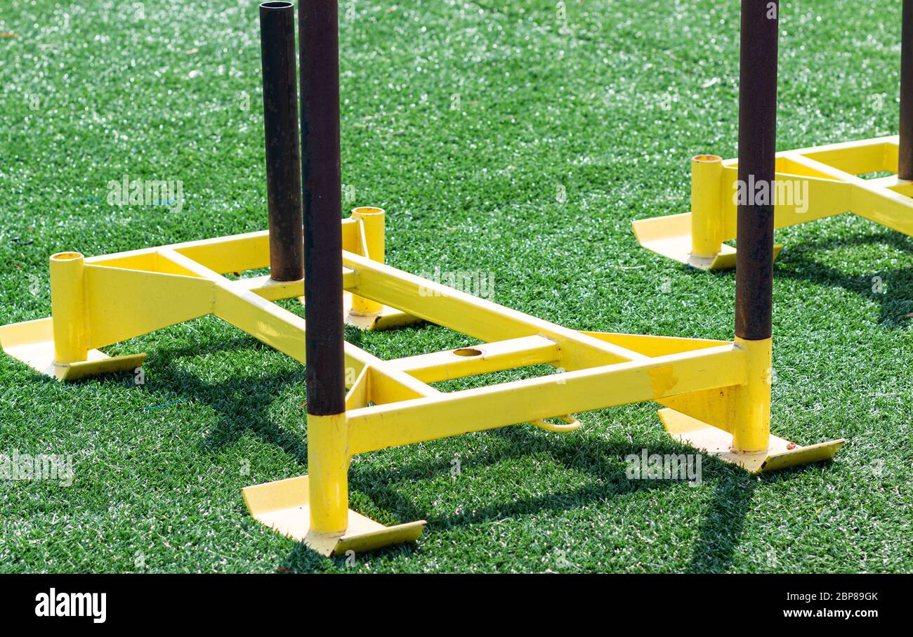 Yellow push sleds are set up for strength practice on a green turf field Stock Photo - Alamy