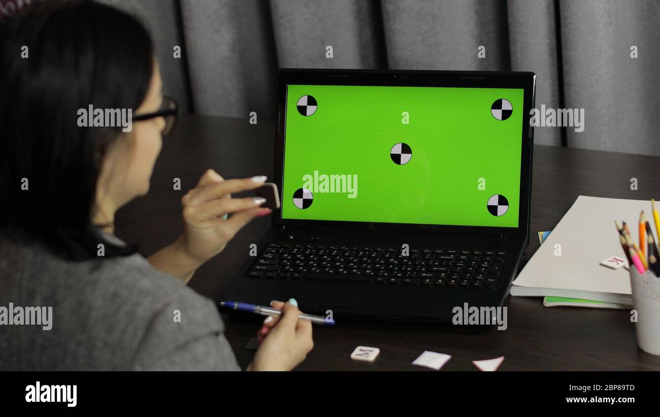 Woman teacher making online video call on laptop with green screen ...