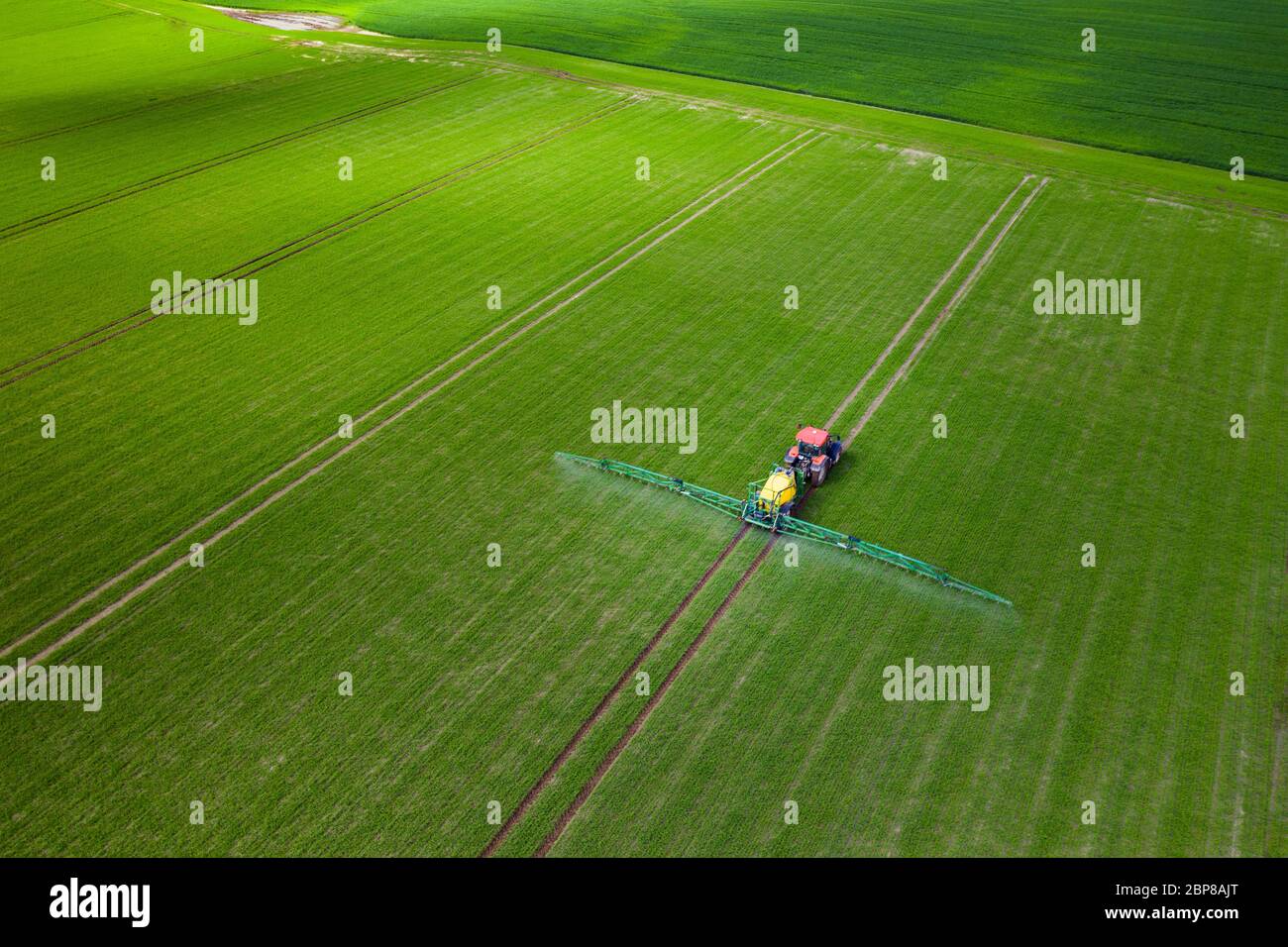 Tractor cultivating green field, aerial view Stock Photo - Alamy