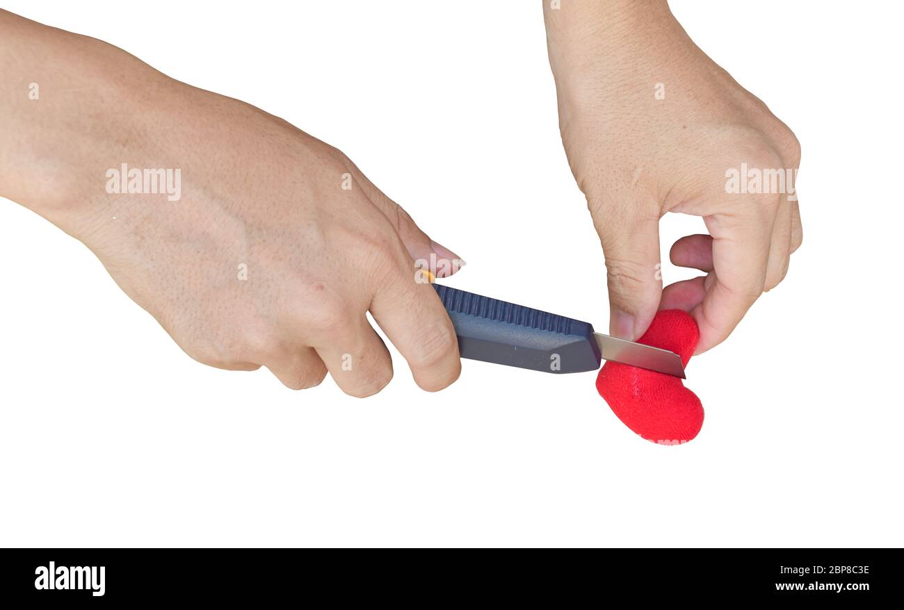 hand holding a knife cutting red heart isolated on white background ...