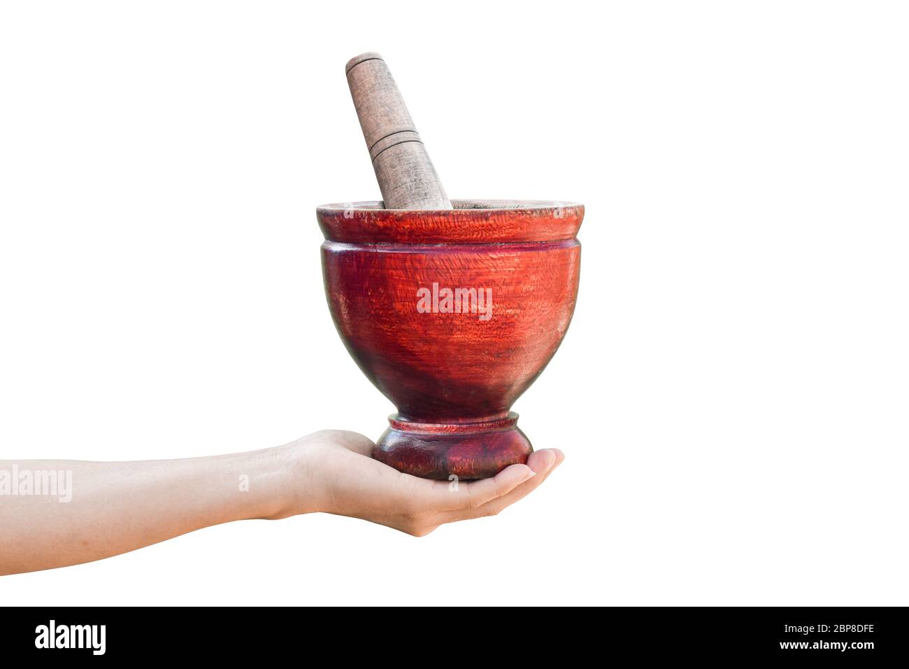 Wooden mortar and pestle in hand isolated on white background with ...