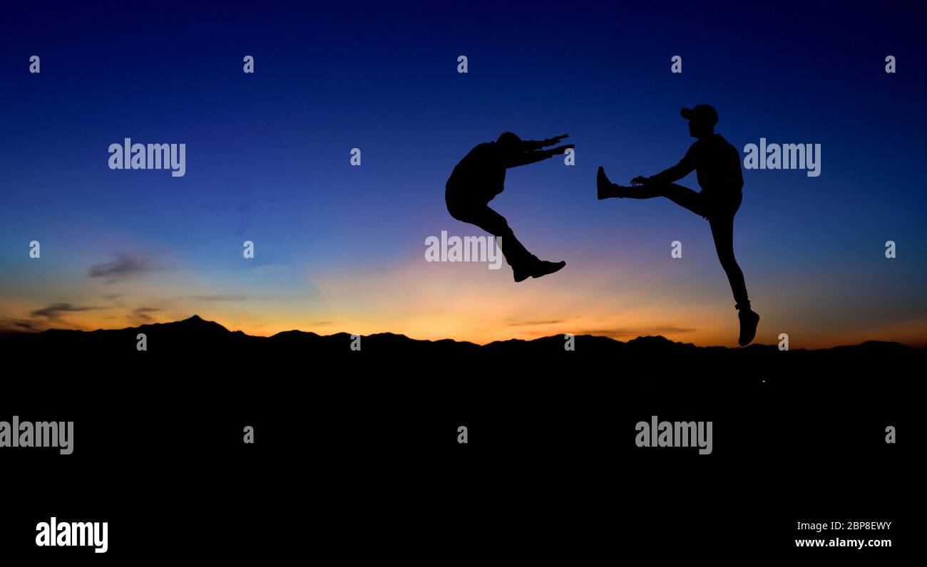 Silhouettes of two male fighters on sunset background Stock Photo - Alamy