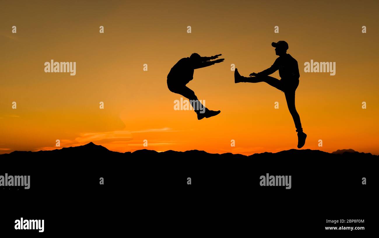 Silhouettes of two male fighters on sunset background Stock Photo - Alamy