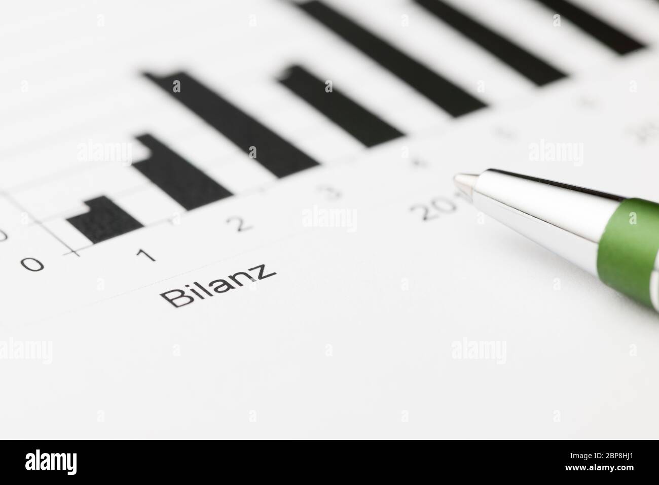 Nahaufnahme eines auf einem Bilanz-Chart liegenden grünen ...
