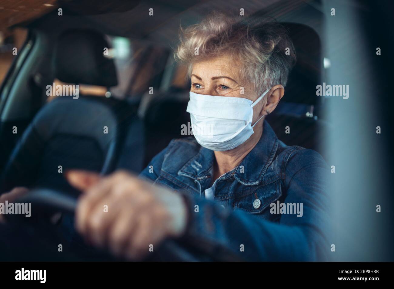 Senior woman driver with face mask in car, quarantine concept Stock ...
