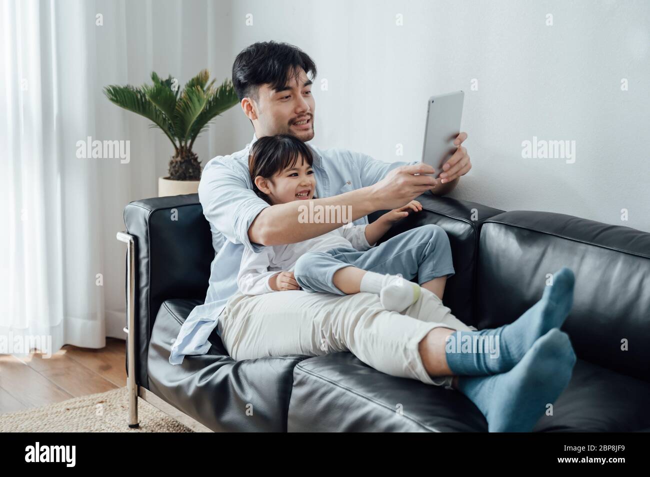 Father and daughter at home using a Tablet PC Stock Photo - Alamy