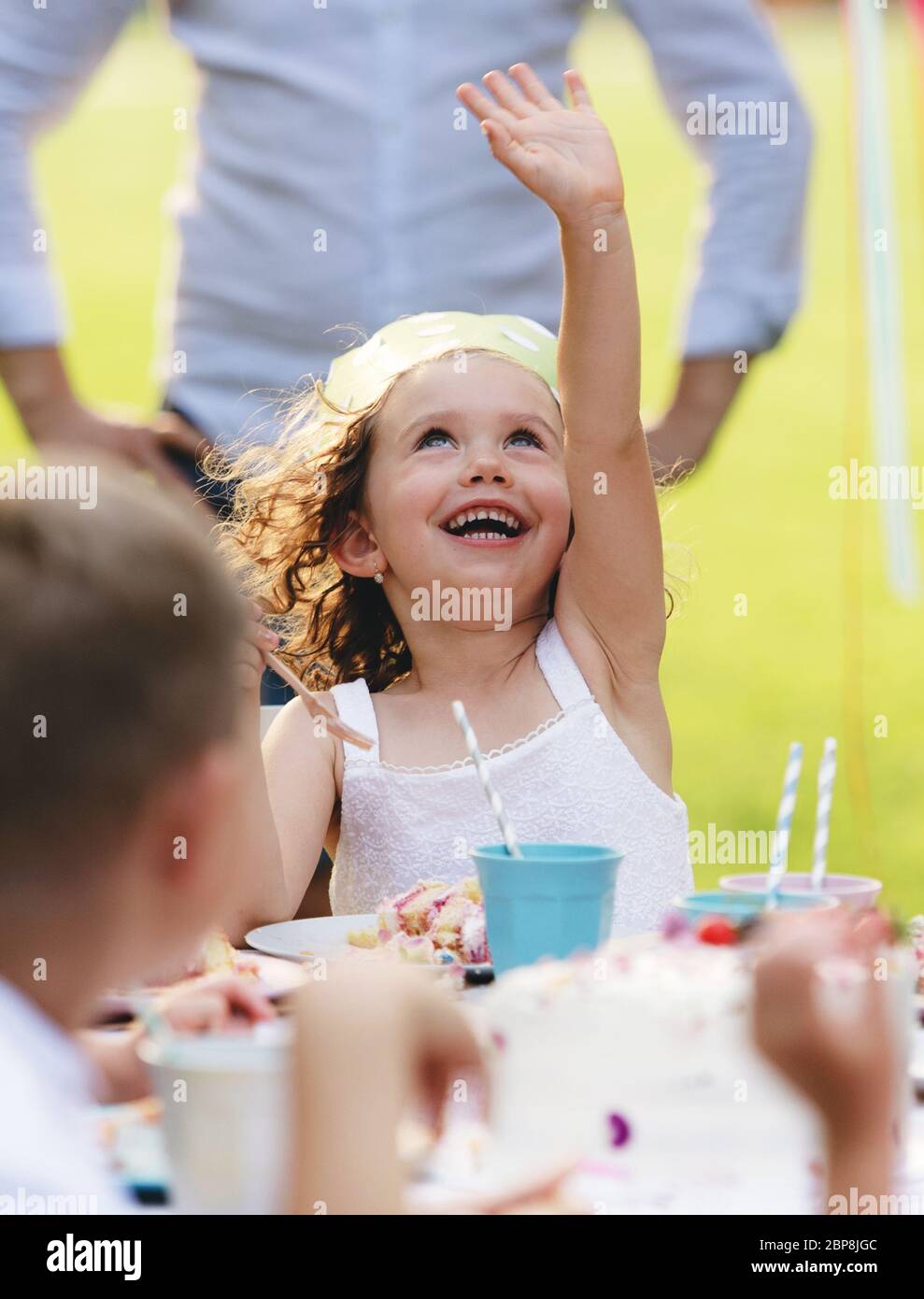 Happy small girl celebrating birthday outdoors in garden in summer ...