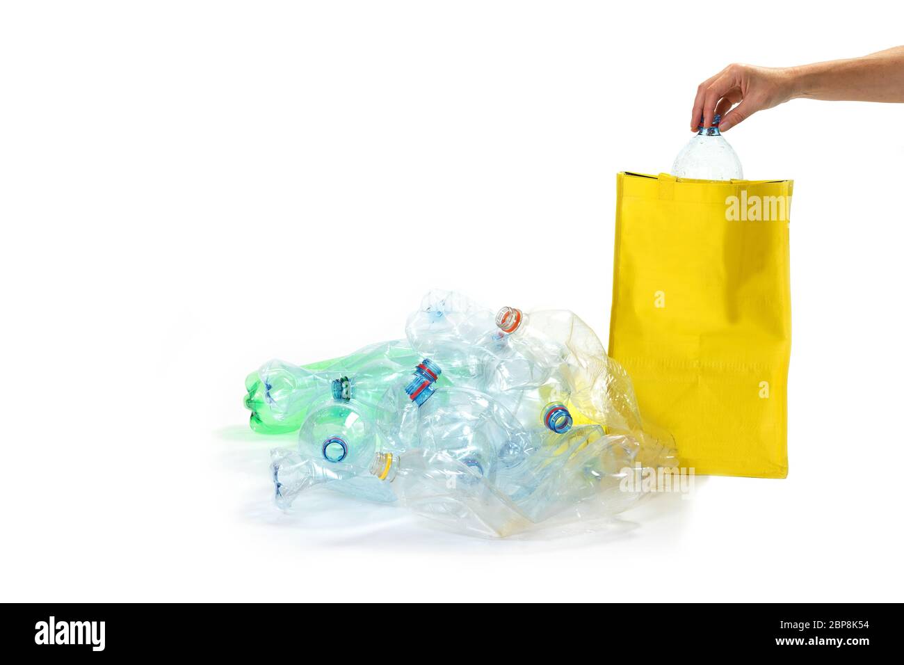 Pile of plastic bottles is lying on the white background. Woman's hand ...
