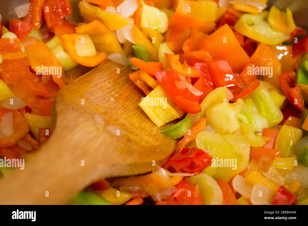 Cooking stew with fresh vegetables in a pot. Mixing it with mixing ...