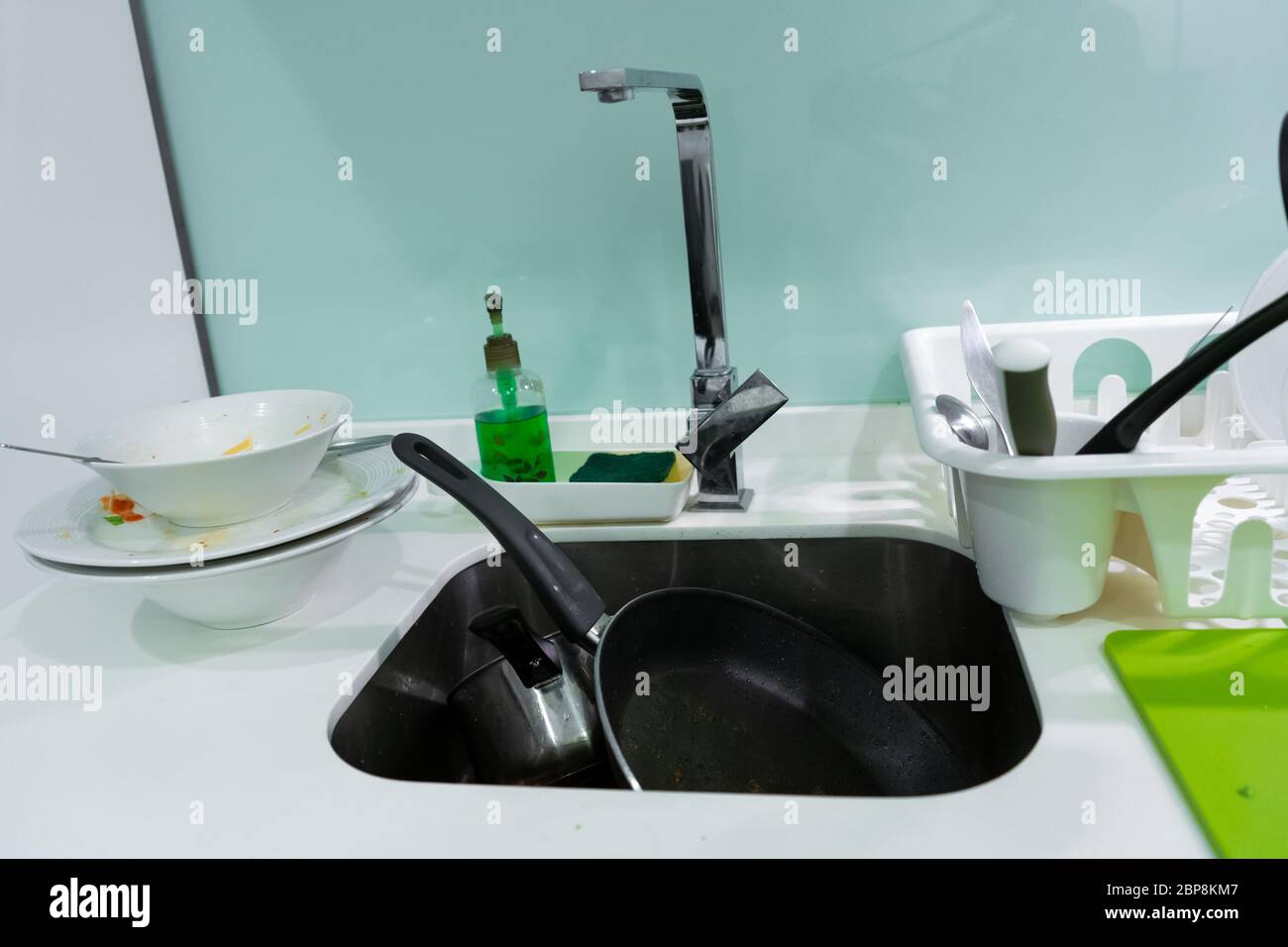 A mountain of dirty dishes in the kitchen sink. Mess in the house Stock ...