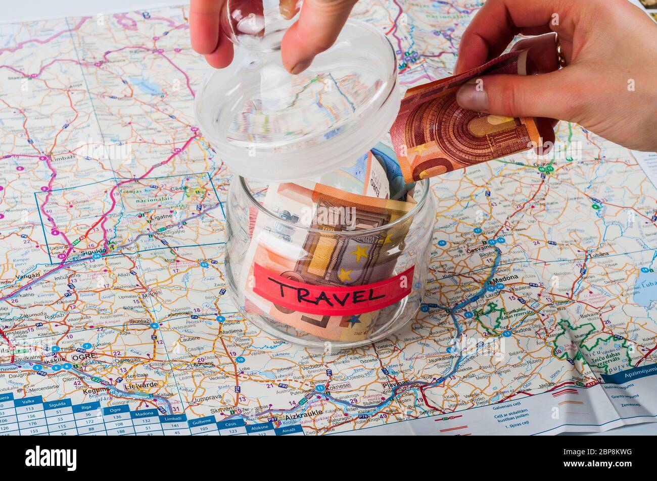 Savings jar for travel on a map Stock Photo - Alamy