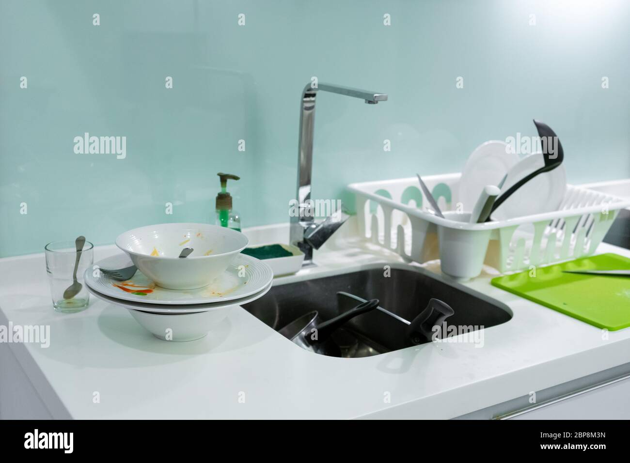 A mountain of dirty dishes in the kitchen sink. Mess in the house Stock ...