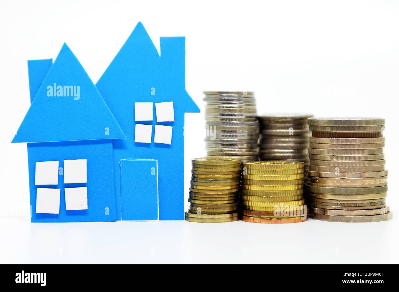 Blue paper house model and stacks of coins Stock Photo - Alamy