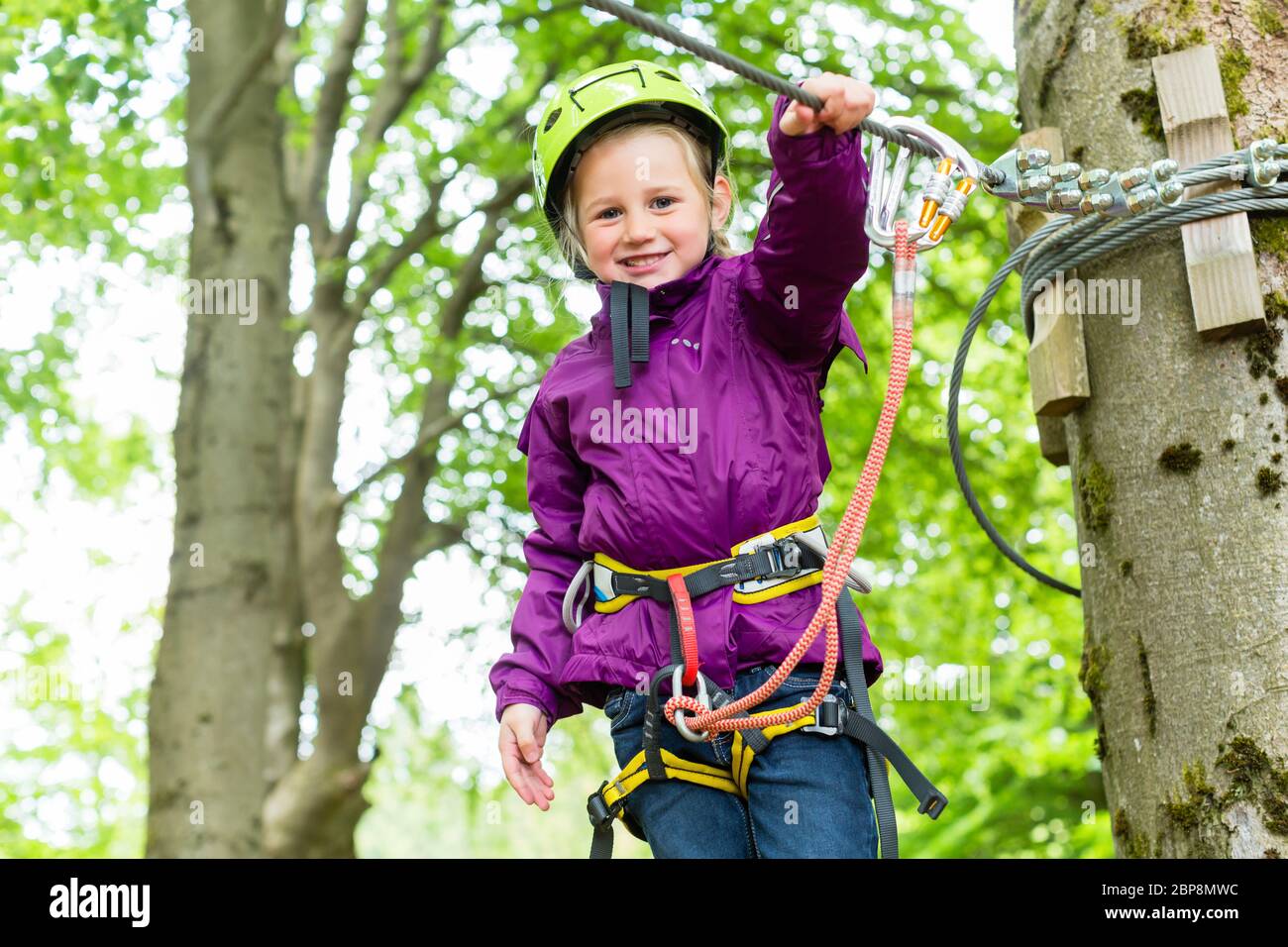 Girl climbing in high rope course enjoying the adventure Stock Photo ...