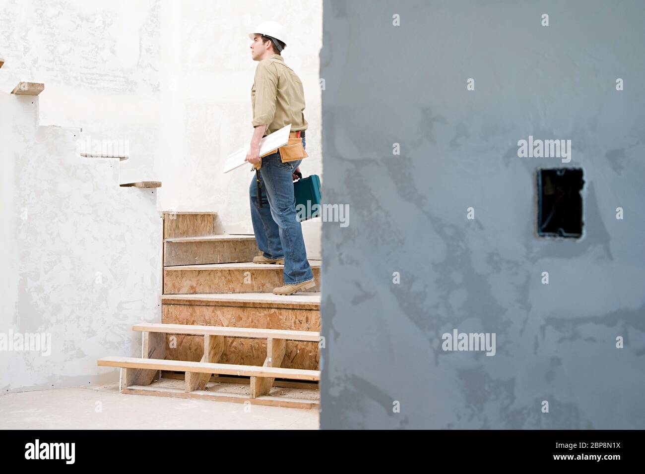 A builder walking up stairs Stock Photo - Alamy