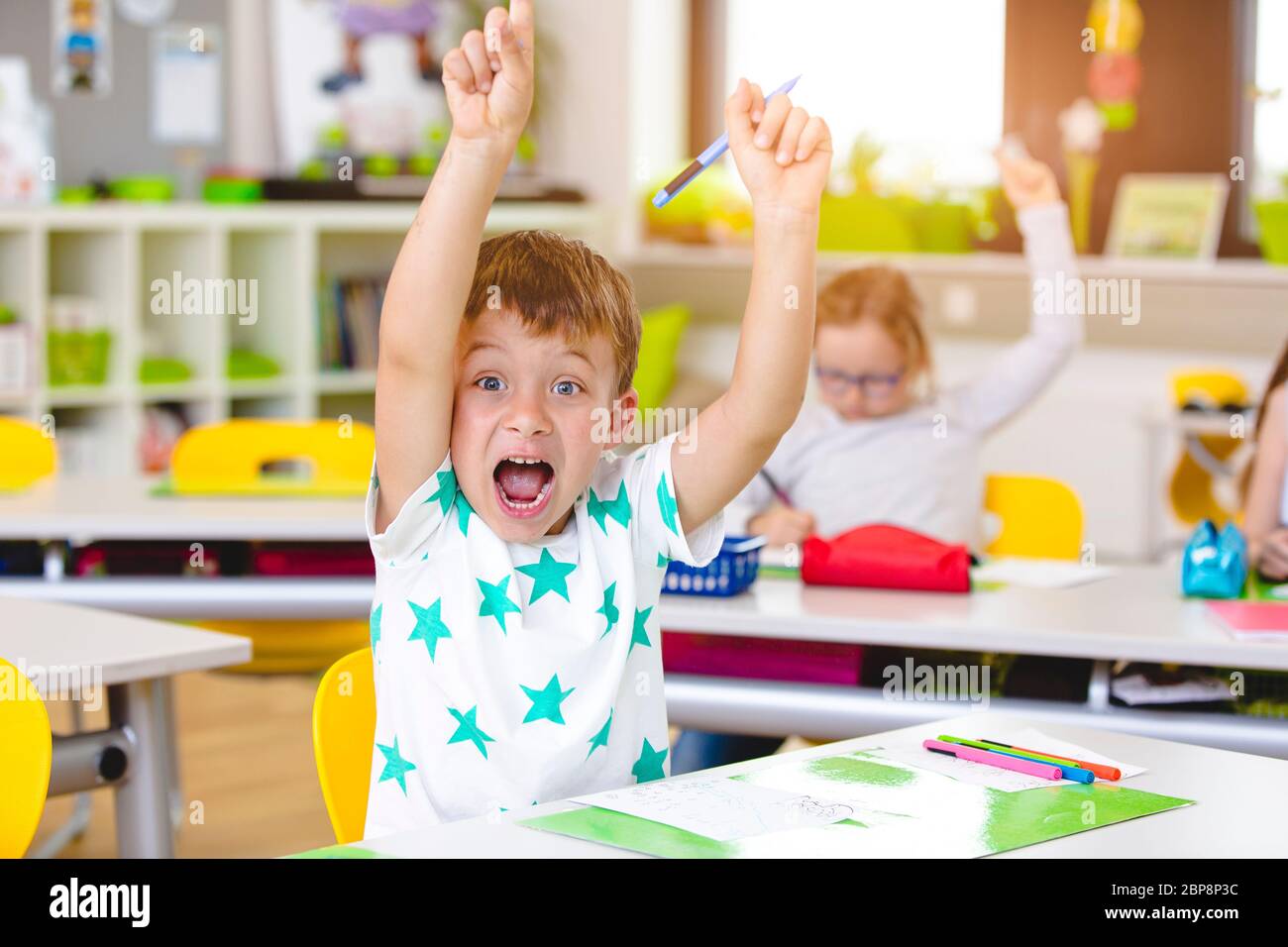 Beautiful young kids have fun in school while learning in classroom ...