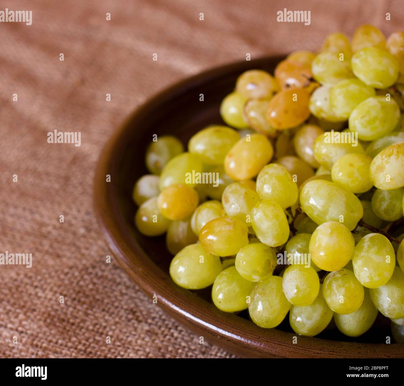 Green grapes on the clay brown dish Stock Photo - Alamy